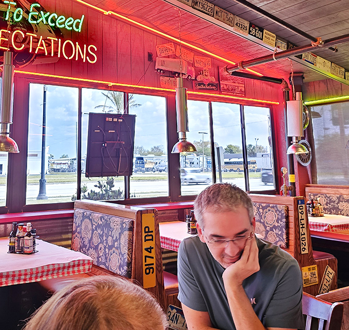 The neon "To Exceed Expectations" sign isn't just decoration&mdash;it's a mission statement illuminating comfortable booths where food memories are made.