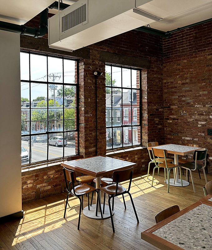 Sunlight streams through industrial windows, warming the exposed brick walls. A quiet corner perfect for contemplating your next meat-venture.