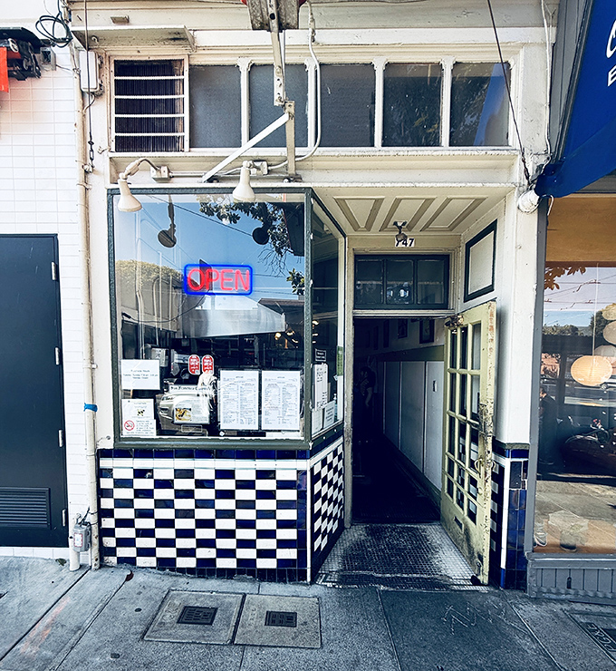 The black-and-white checkered entrance feels like stepping into a breakfast time machine. Small door, big flavors await inside.