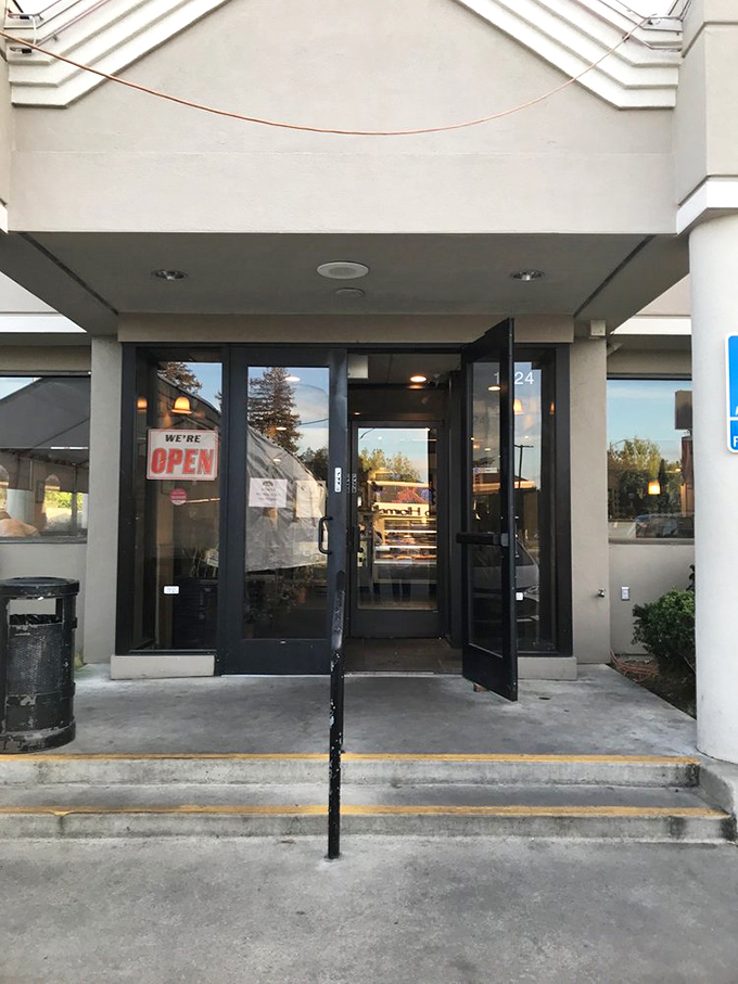 The entrance beckons with a simple "OPEN" sign &ndash; two syllables that promise culinary happiness awaits just beyond those doors.