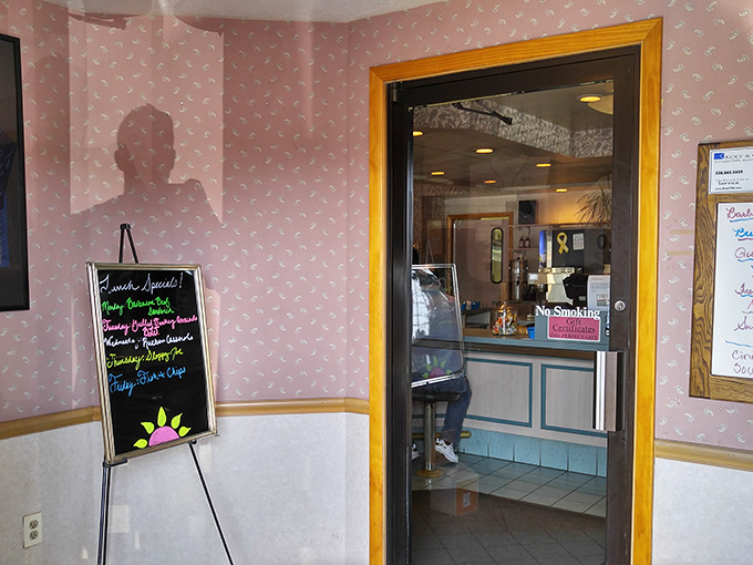 A chalkboard announces daily specials with colorful flair, standing sentry at an entrance that divides the ordinary world from breakfast paradise.