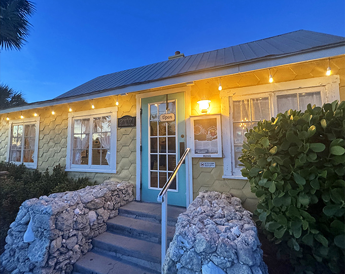 As dusk falls, string lights transform this yellow cottage into a glowing invitation. The turquoise door practically winks at passersby.
