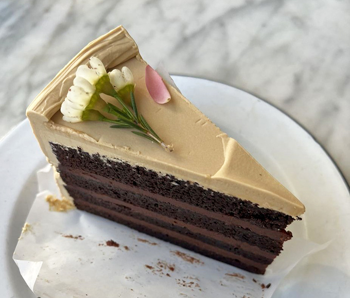 A slice of cake so perfectly constructed it could have its own architectural review. Chocolate layers supporting caramel frosting in delicious structural harmony.