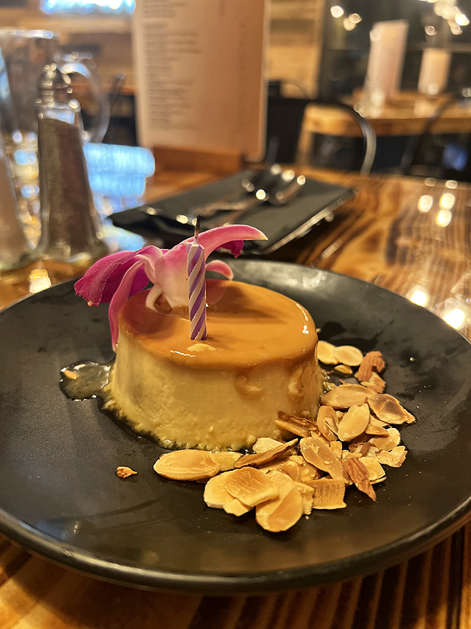 A flan that jiggles with confidence, crowned with caramel and surrounded by almond shards like a dessert wearing its Sunday best. 