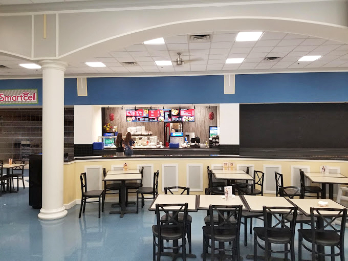 The food court counter stands at the ready, prepared to refuel shoppers with the universal mall cuisine that somehow tastes better when eaten between purchases.