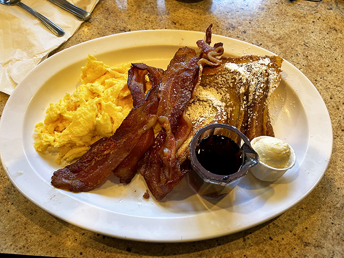 Breakfast that makes you want to high-five the chef. Golden French toast, crispy bacon, and eggs that belong in a sunrise painting.