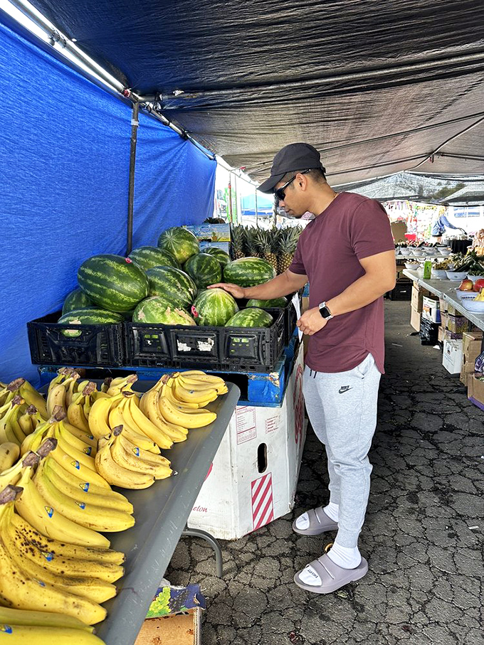 The watermelon whisperer selects the perfect specimen. Fresh fruit vendors offer a healthy counterpoint to the inevitable food truck indulgences.