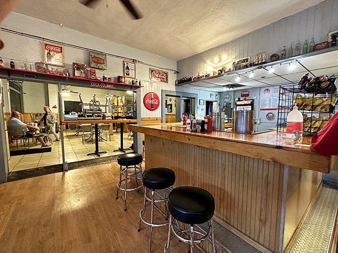 The counter where magic happens—simple ingredients transformed into memorable meals under the watchful gaze of vintage Coca-Cola signs.