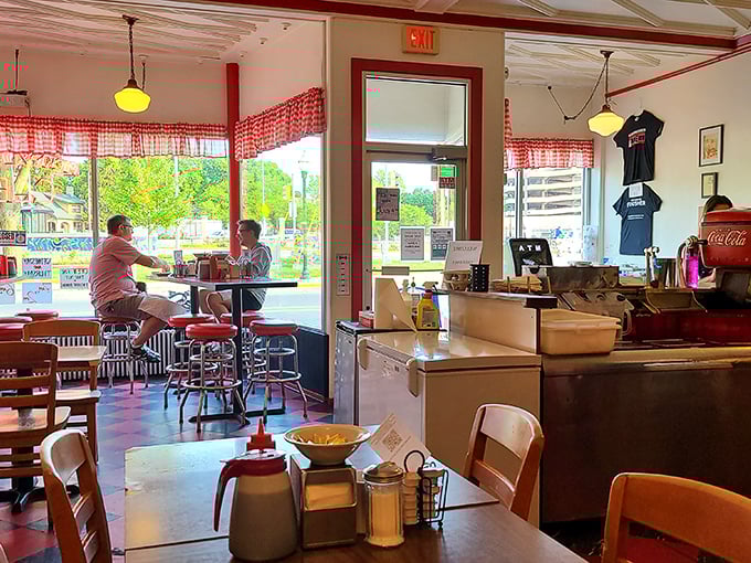 Sun streams through windows onto red-checkered curtains, creating the perfect backdrop for conversations that meander like Sunday mornings.