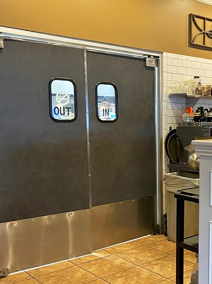 Kitchen doors marked "IN" and "OUT"&mdash;a simple system ensuring your breakfast emerges from organized chaos rather than just chaos.