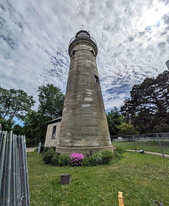 The iron fence surrounding the lighthouse isn't just for protection&mdash;it's framing a perfect picture that belongs on your holiday card.
