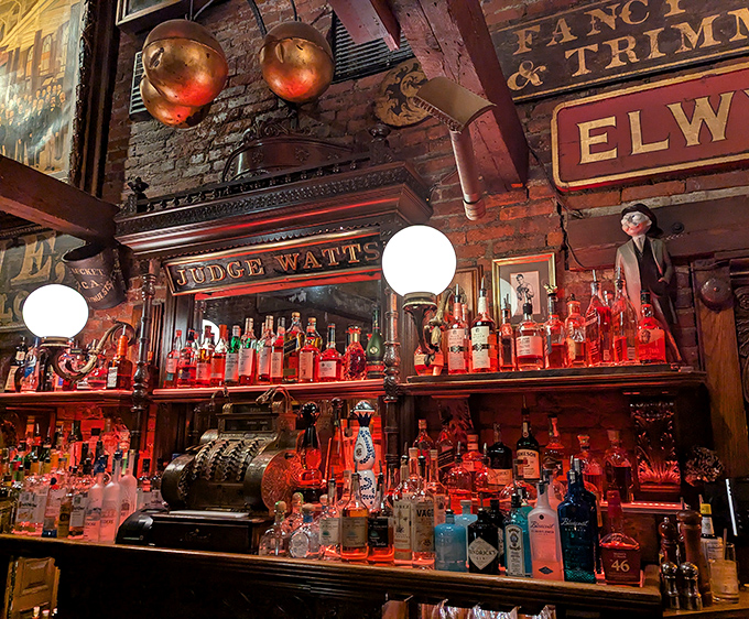 This isn't just a back bar—it's a shrine to spirits where the red glow makes every bottle look like it contains something magical and slightly dangerous.
