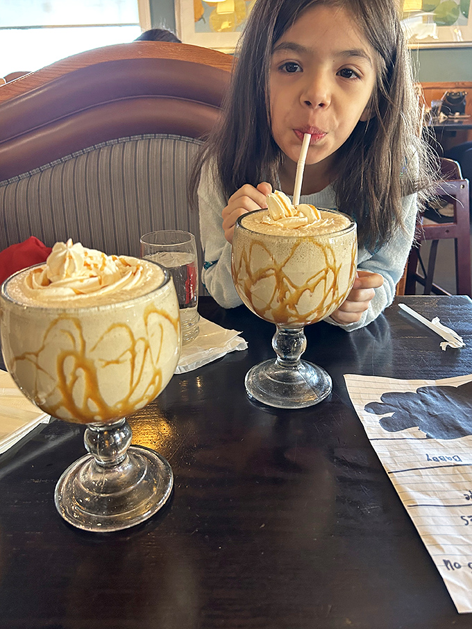 Dessert becomes an event with these towering caramel-drizzled treats. The look of pure joy says everything about the universal language of sweet indulgence.