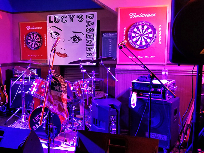 The stage is set for live music that pairs perfectly with cold drinks and hot food. Lucy's Basement sign promises nights to remember (or pleasantly forget).