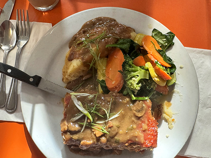 Comfort food gets the gourmet treatment with this meatloaf plate, accompanied by seasonal vegetables that actually deserve your attention.