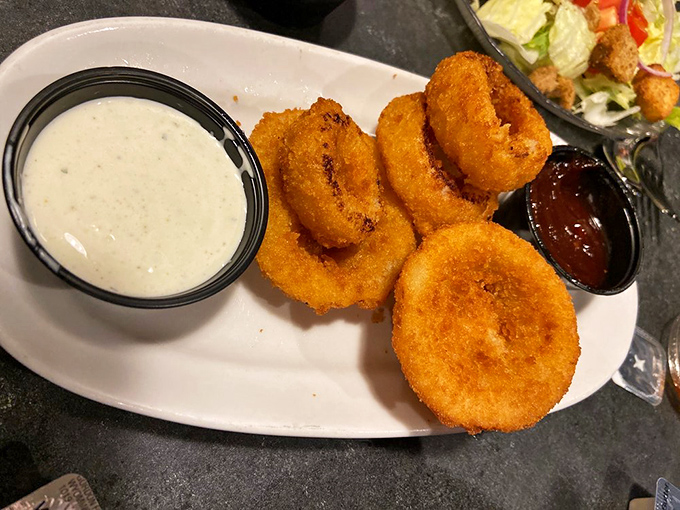 Onion rings with the perfect crunch-to-squish ratio, flanked by dipping sauces that make you forget ketchup ever existed.