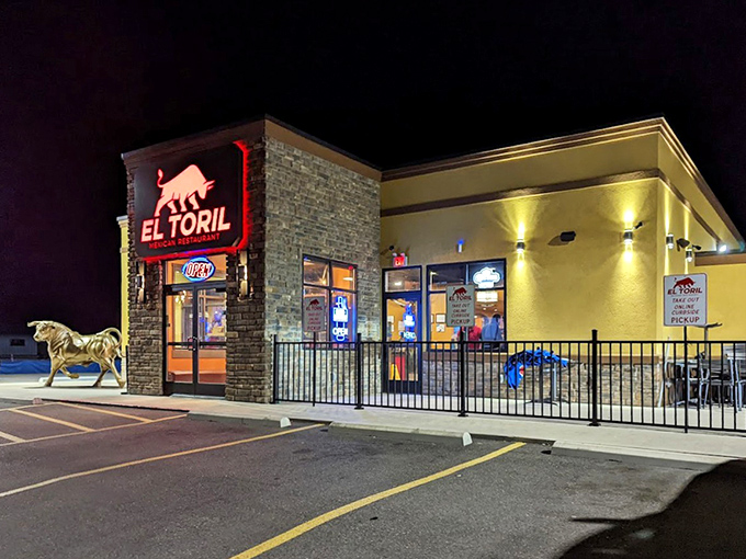 El Toril's nighttime exterior glows invitingly, the golden walls and red signage creating a warm oasis in the darkness.
