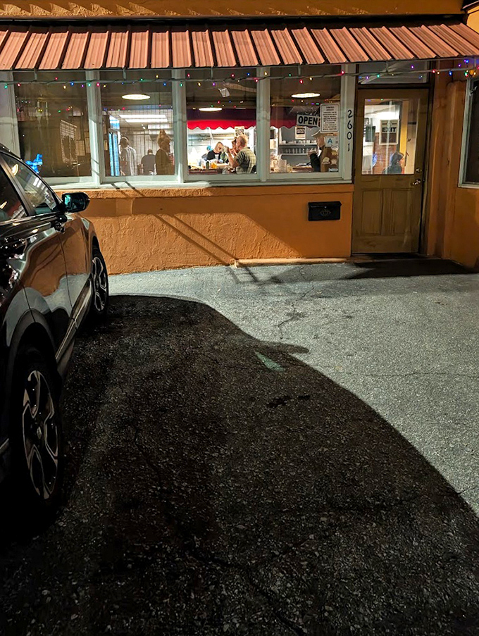 Evening diners glimpsed through windows framed by twinkling lights. Some of life's best conversations happen over shared plates of hummus.