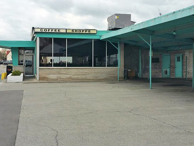 The "Coffee Shoppe" sign promises liquid motivation. This side entrance has welcomed morning regulars seeking caffeine and conversation for generations.