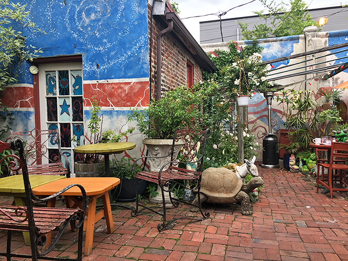 The outdoor garden feels like stumbling into a secret urban oasis, where colorful tables and lush plants create a retreat from city life.