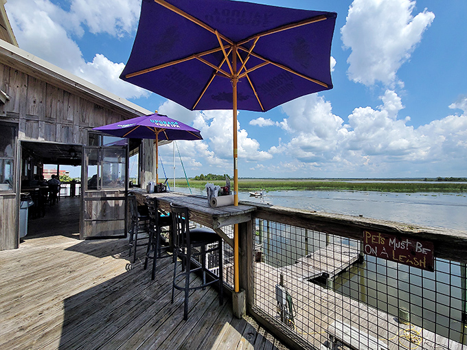 Purple umbrellas shade outdoor seating where the line between restaurant and waterfront blurs &ndash; dining with your toes practically in the tide.