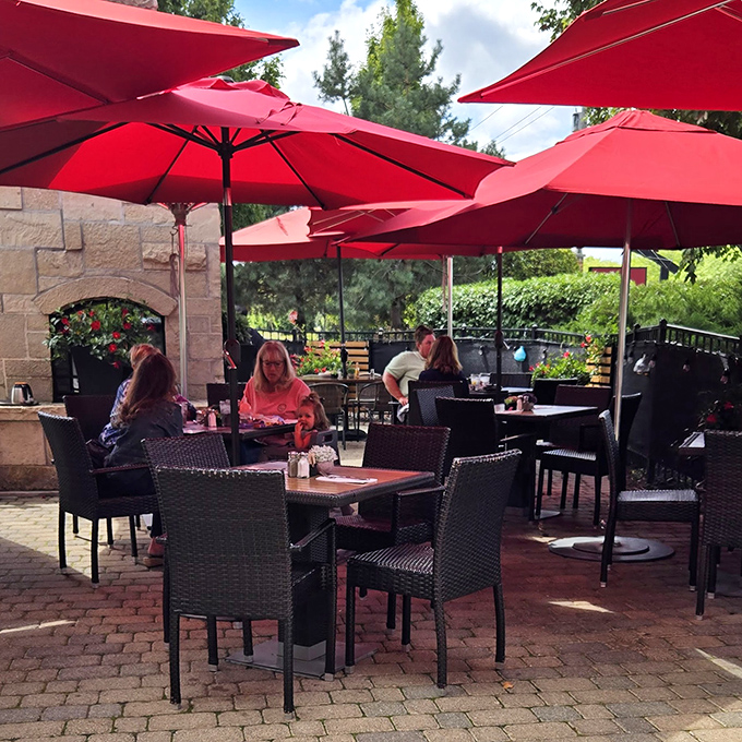 Outdoor dining under crimson umbrellas &ndash; where breakfast meets fresh air in a patio setting that makes every meal feel like a mini-vacation.
