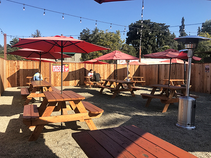 The outdoor seating area, where picnic tables under red umbrellas invite you to enjoy your feast with a side of California sunshine.