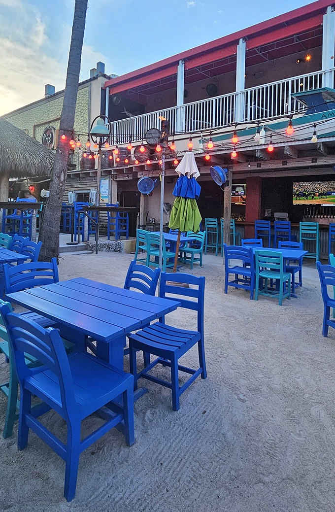 Beach vibes intensify with these brilliant blue chairs and string lights &ndash; dinner with your toes in the sand is what vacation dreams are made of.