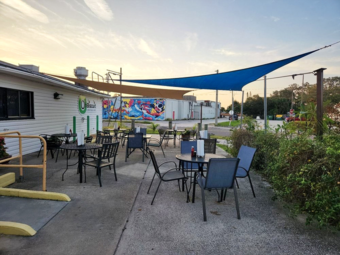 Sunset dining under blue canopies creates the perfect evening ambiance. Florida's gentle breezes complement the casual outdoor setting.