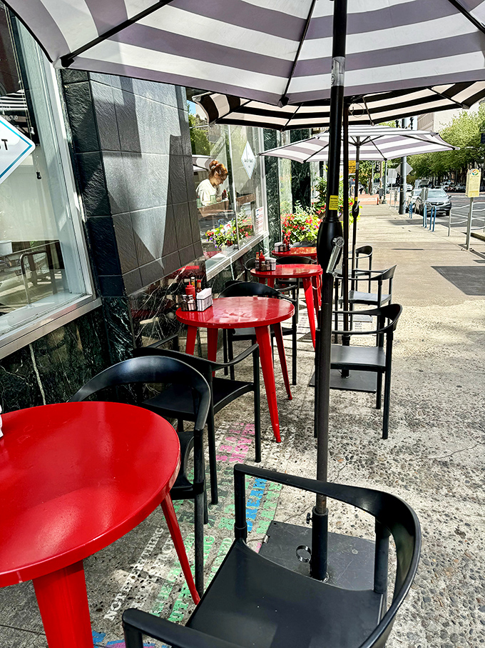 Outdoor tables under striped umbrellas create an urban oasis where your coffee stays cool and your conversation flows freely.