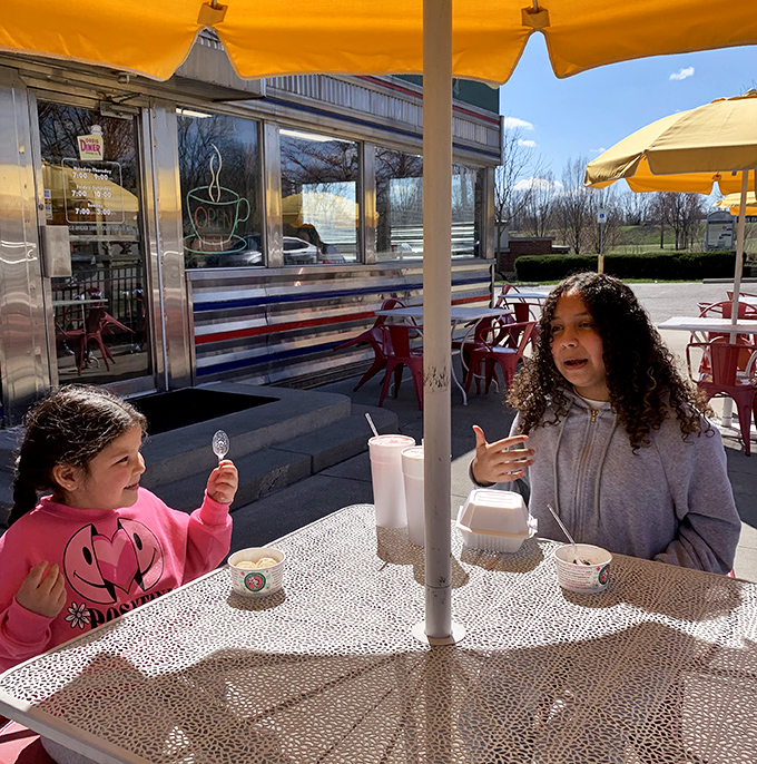 Outdoor dining under yellow umbrellas&mdash;where milkshakes taste better with sunshine and conversations come with a side of fresh air.