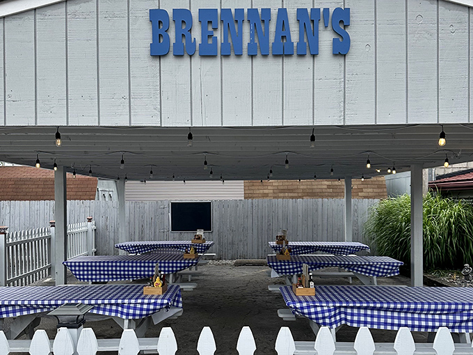 The outdoor dining area offers a breath of fresh air with classic blue-checkered tablecloths that practically whisper "sit down, relax, and prepare for something wonderful."