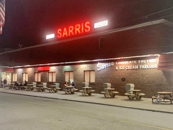 After dark, the Sarris sign glows like a beacon of hope for those with dessert emergencies. Those picnic tables have heard countless sugar-fueled conversations.
