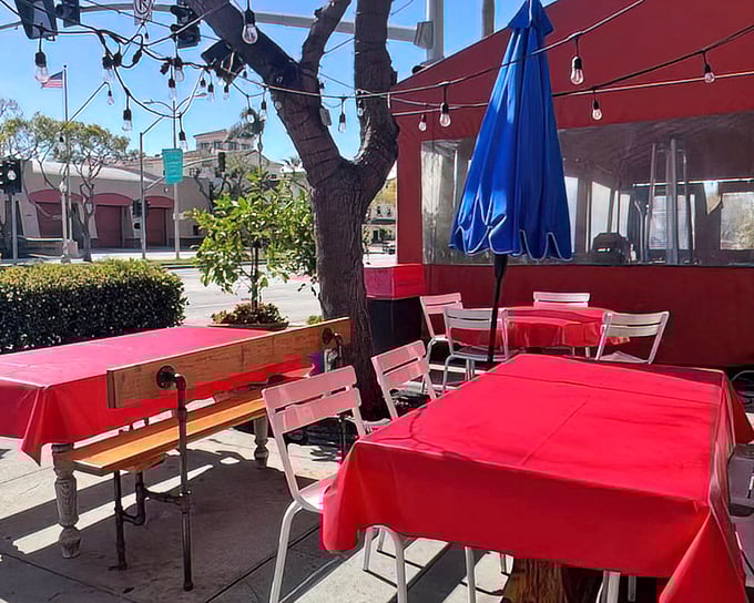 Al fresco dining with vibrant red tablecloths under string lights. California sunshine and fried chicken&mdash;a match made in culinary heaven.