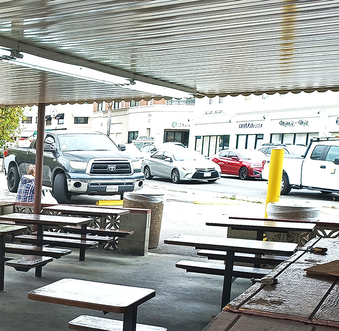 The parking area fills daily with vehicles whose owners are united by one common mission: the pursuit of pastrami perfection.