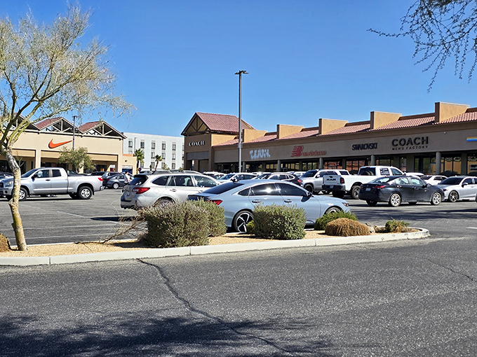 A panoramic view of retail heaven where Coach, New Balance, and Nike coexist in harmony under the brilliant blue desert sky.