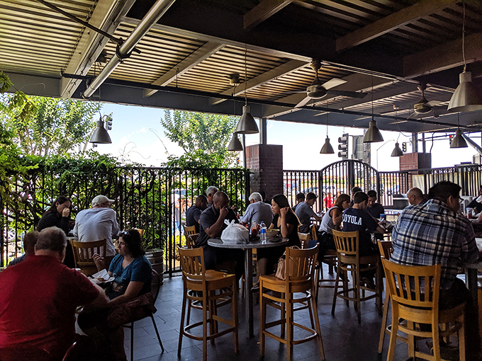 The covered patio offers al fresco dining with a side of people-watching, where wooden chairs and ceiling fans create the perfect environment for lingering lunches.