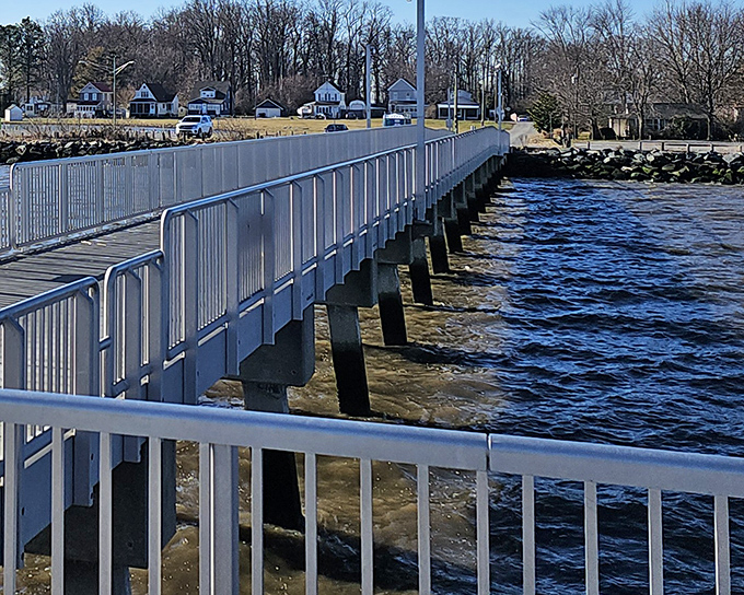 The fishing pier stretches toward the horizon like a runway for dreams, inviting visitors to walk above the gentle waves.