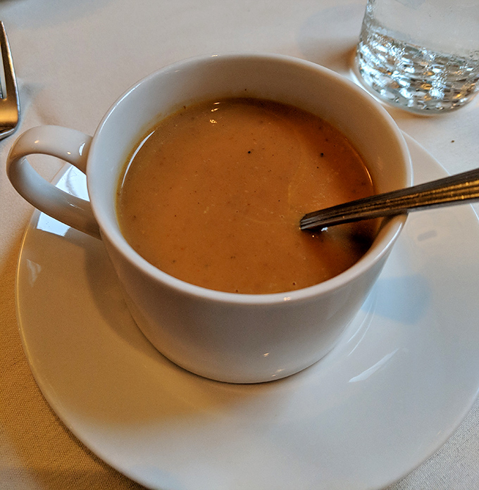 Velvety pumpkin soup that warms not just your body but your soul—autumn's essence captured in a simple white cup.