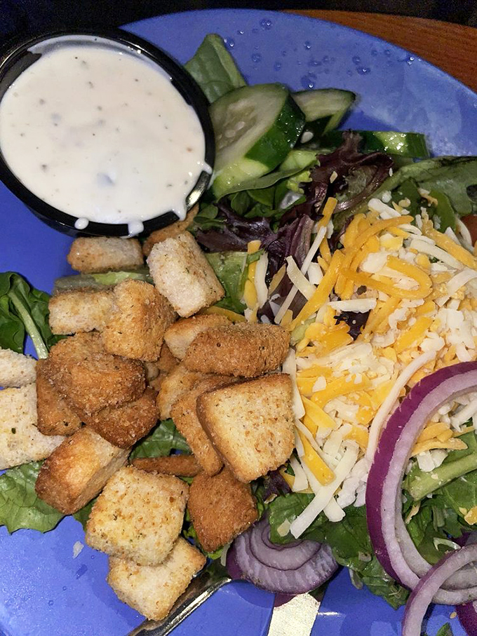 A garden of greens crowned with croutons that crunch like tiny flavor castles, proving that even salads deserve their moment in the sun.