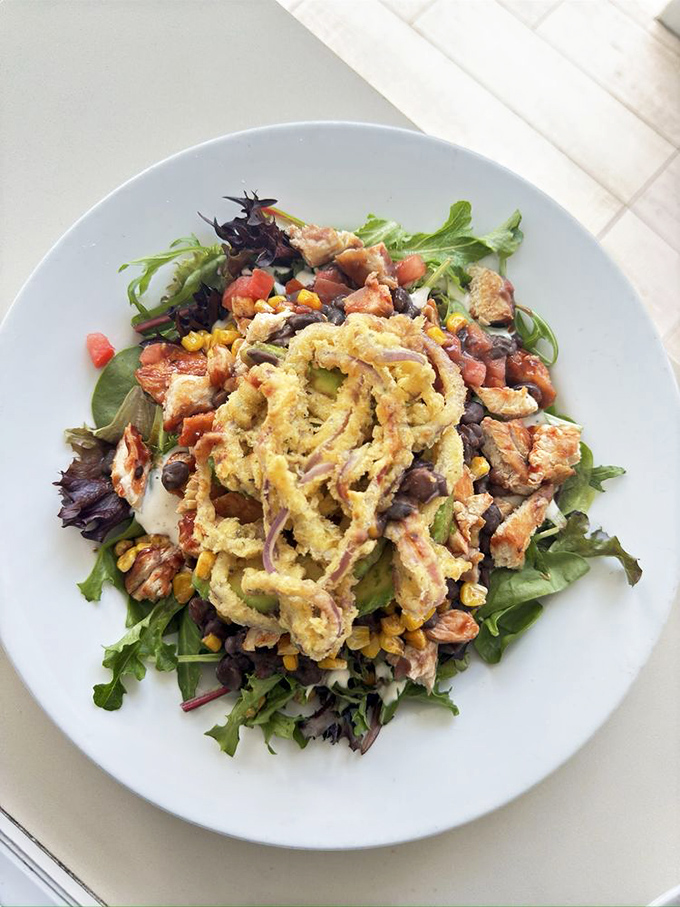 A salad that somehow crashed the breakfast party and got everyone's approval. Those crispy onion rings on top are wearing the crown.
