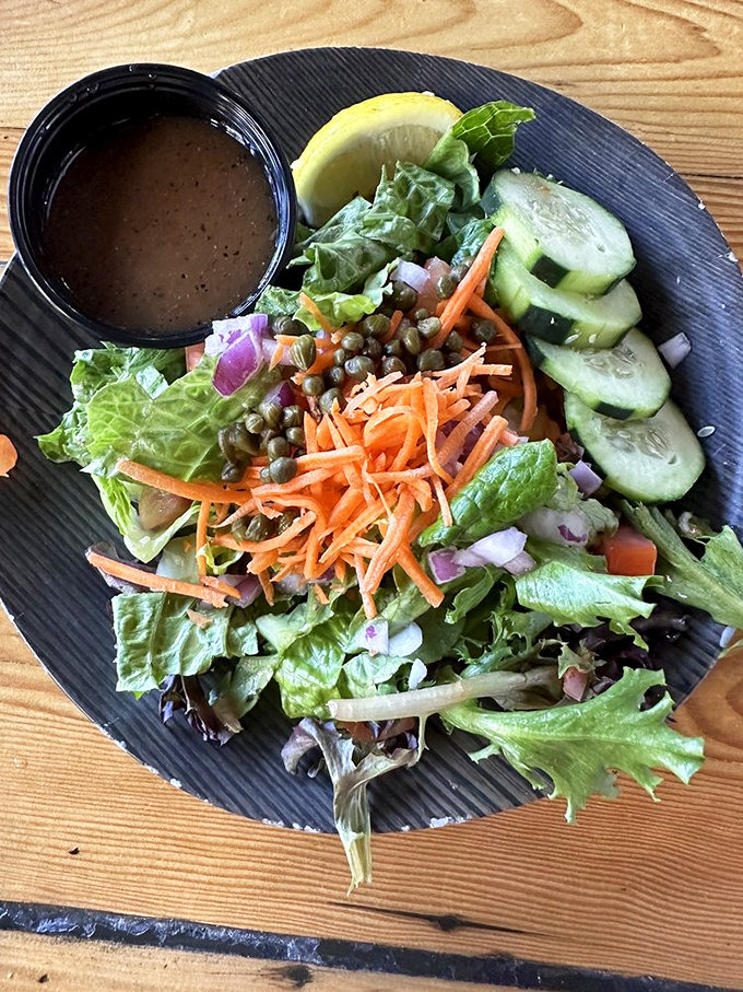 A salad that doesn't apologize for being healthy. Crisp greens, vibrant carrots, and tangy capers prove that not all seafood companions need to be fried.