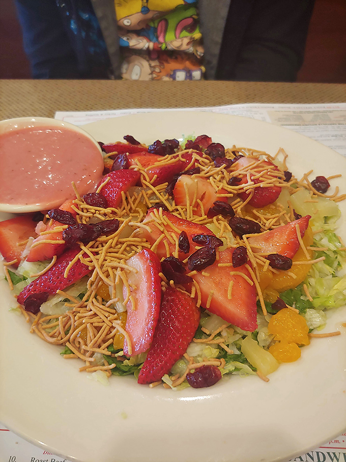 Fresh strawberries, dried cranberries, and shredded cheese transform simple greens into a colorful, satisfying meal option.