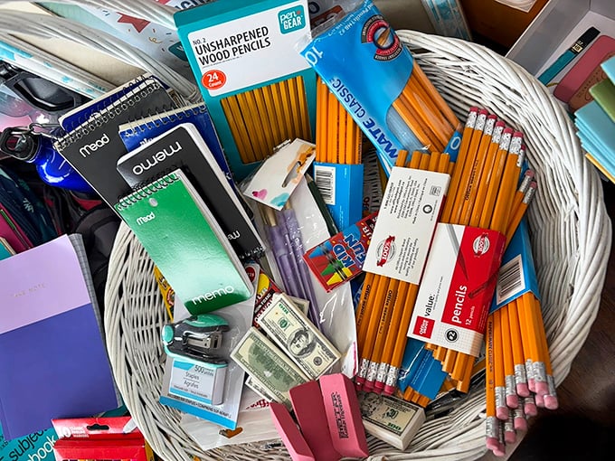 School supplies nestled in a basket like a teacher's dream&mdash;pencils, erasers, and even play money for those "real-world math" lessons.