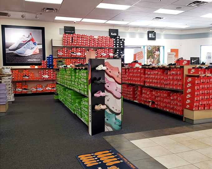 The Nike Factory Store's rainbow of shoe boxes stacked like a retail Tetris game promises athletic footwear at prices that won't make you sweat.