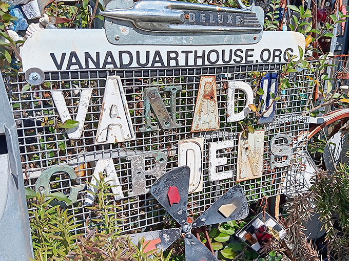 The official signage announces itself with appropriate metallic flair. Even the website address becomes part of the artistic tapestry.