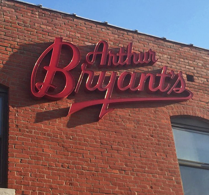 That red sign against the brick exterior is more than just a logo—it's a promise of smoky delights within.