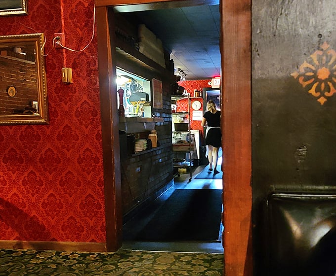 The hallway's red damask wallpaper creates the perfect dramatic entrance&mdash;like the restaurant equivalent of a theatrical curtain rising.