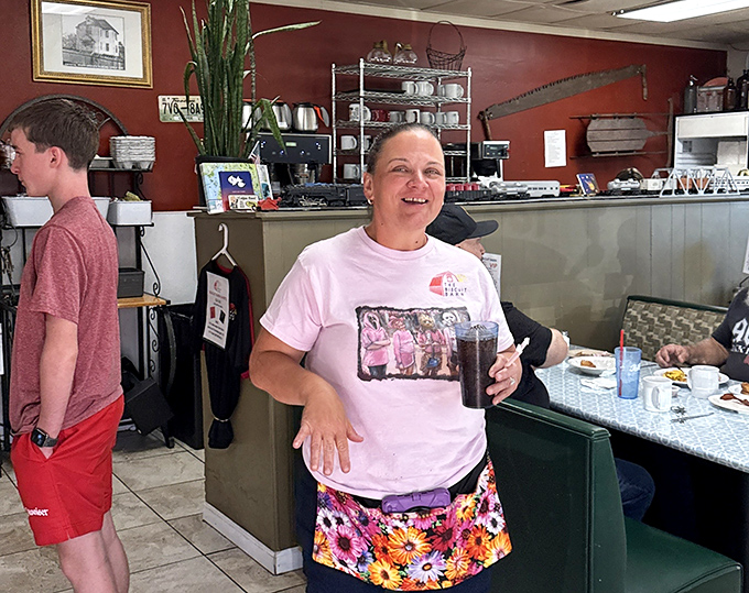 The genuine smile of someone who knows they're serving food that makes people drive across county lines just for breakfast.