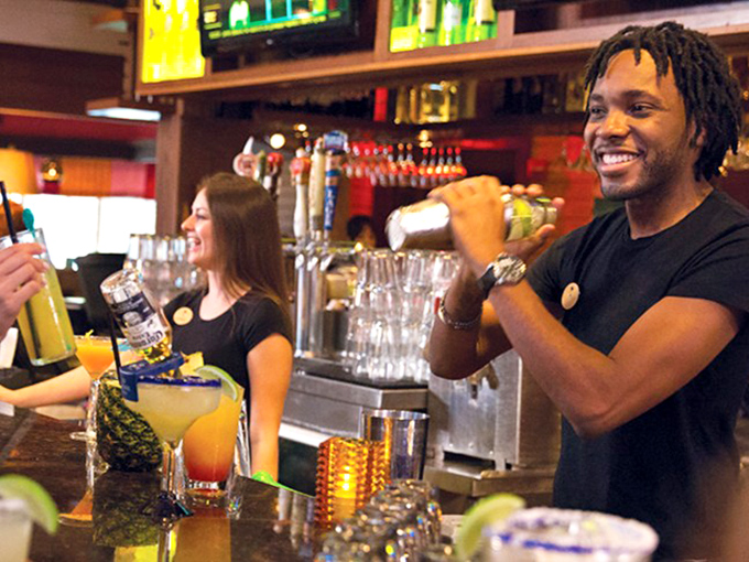 Behind the bar, mixologists craft liquid sunshine with the kind of smile that suggests they know exactly how good your day is about to get.